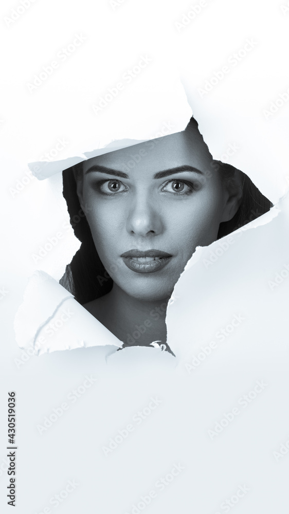 Beautiful young girl looking through hole in paper wall. aspect ratio ...