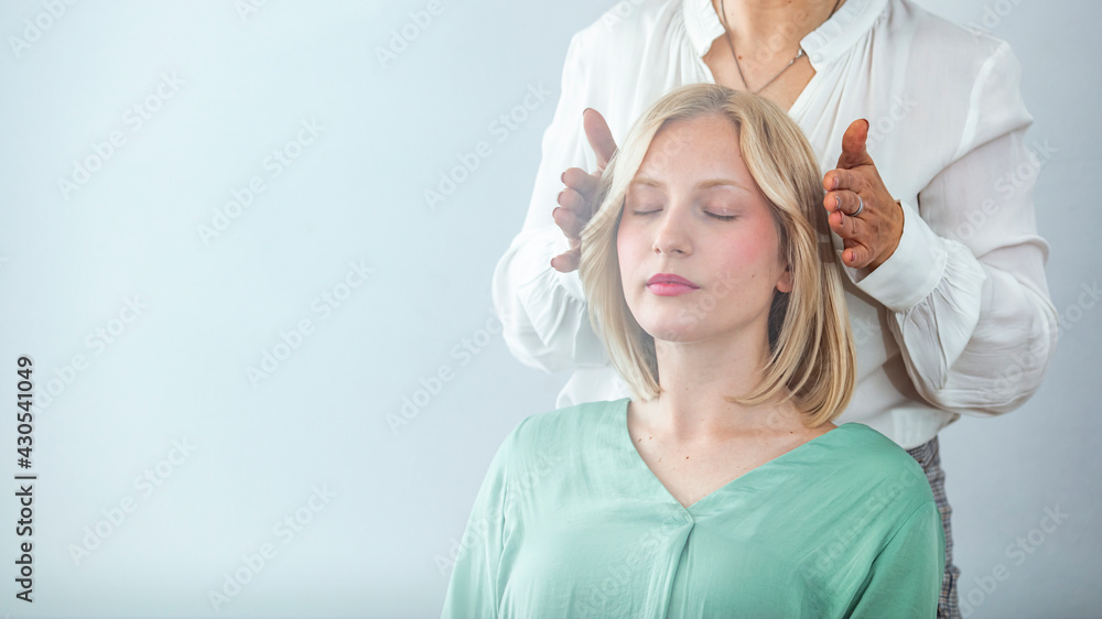 Professional Reiki healer doing Reiki treatment to young woman in ...