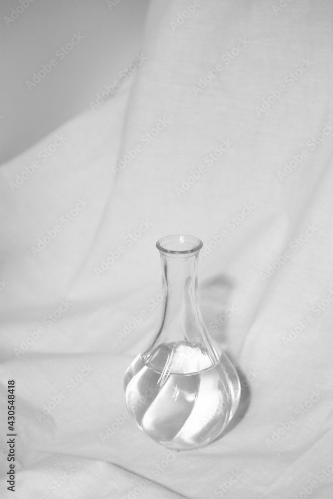 Round crystal vase with water on white linen fabric background ...