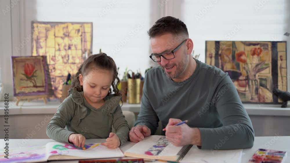 Caring dad drawing with colored crayon pencils with child girl sitting ...