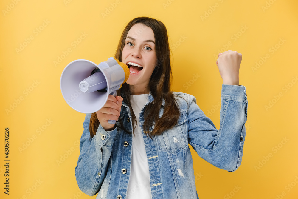 Funny young woman screaming in megaphone doing winner gesture, wears ...