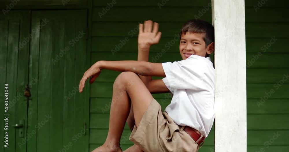 Slow motion scene of a smiling poor Asian elementary school student boy ...