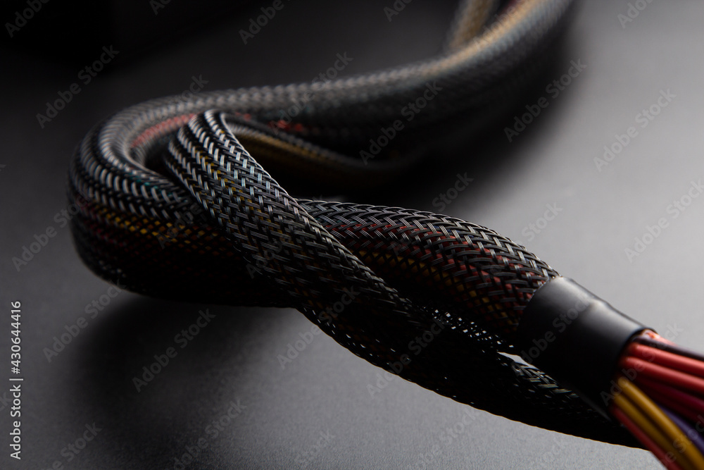 Cable snake skin. Black braided wires in bundle on black background ...