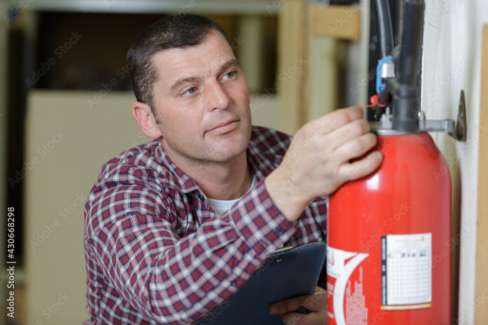 man using fire extinguisher against grey background Stock Photo | Adobe ...