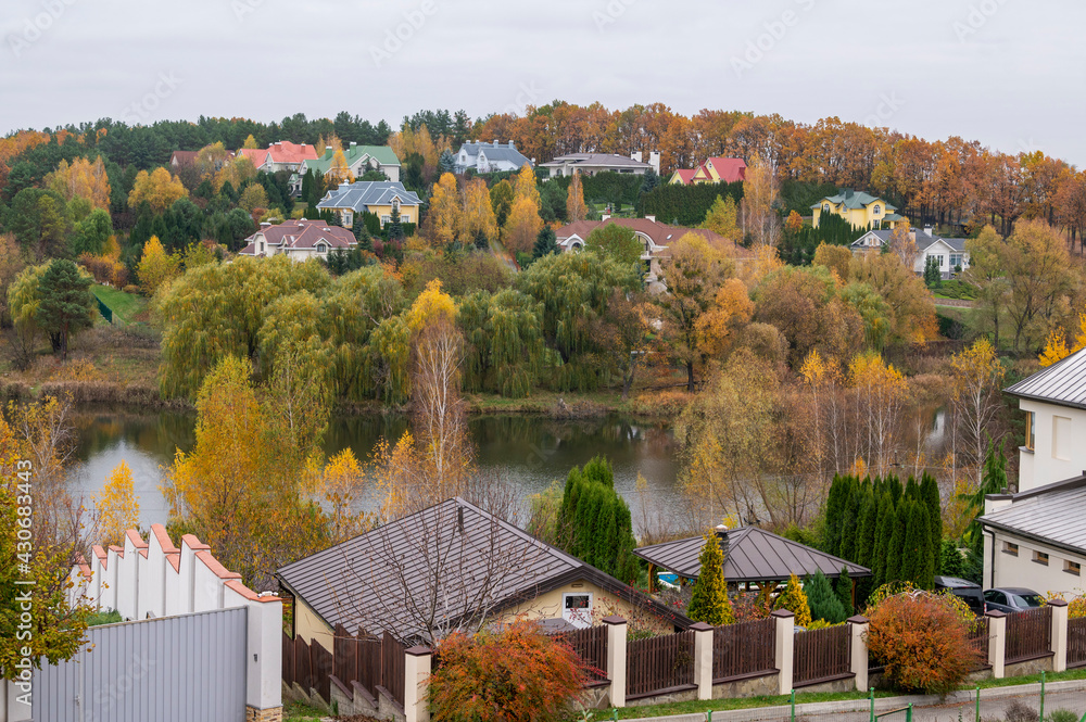 autumn landscape of a suburban village with private houses and fences ...