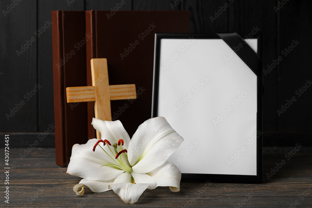 Photo frame with lily flower and cross on dark wooden background Stock ...