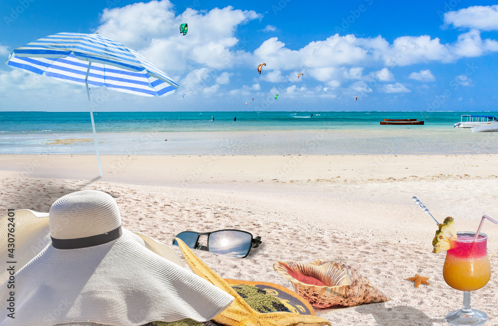 Mise en scène sur plage paradisiaque, parasol, capeline, cocktail ...