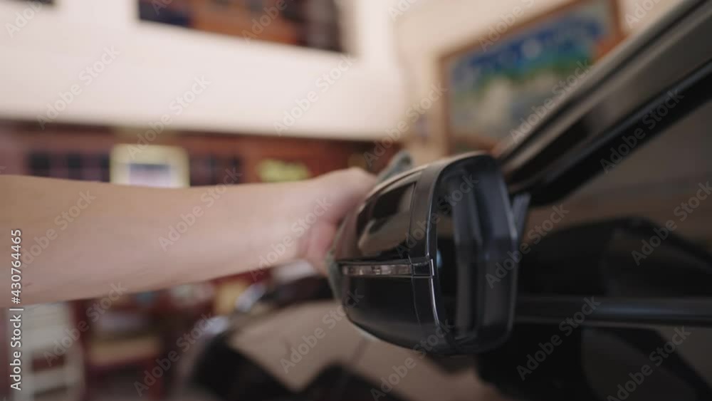 asian male hand cleaning his side car mirror by using wet towel cloth ...