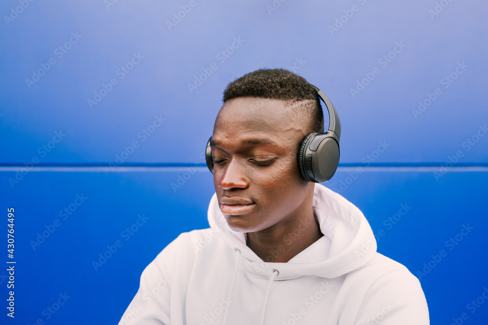 Foto de Young afro American black man listening music with wireless ...