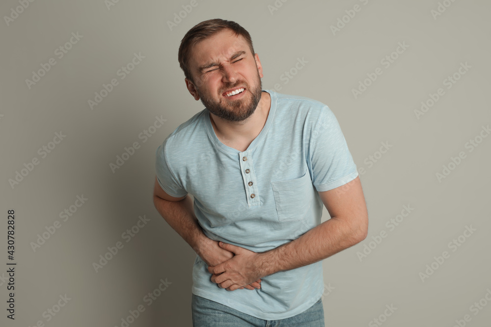 Man suffering from acute appendicitis on light grey background Stock ...