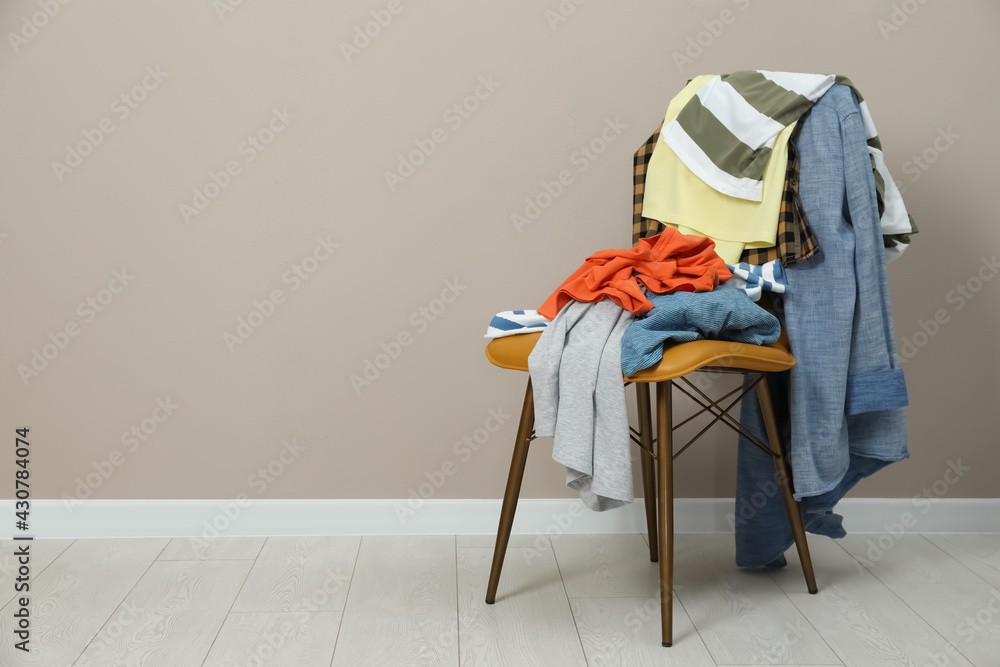 Different clothes on chair near light grey wall, space for text Stock ...