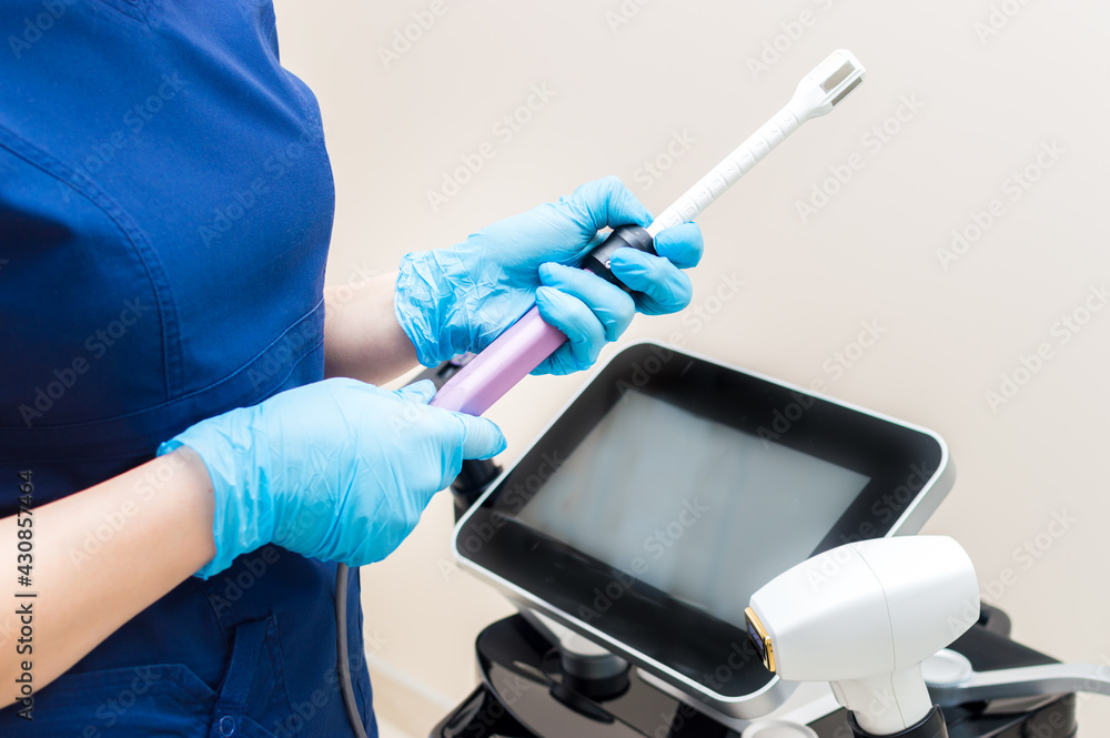 gynecologist works with a RF lifting device. Intimate rejuvenation ...