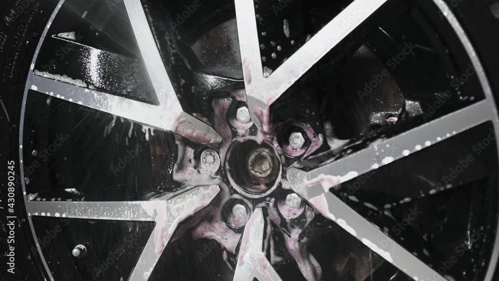 Washing the car wheel rims with neutral pH detergent that removes ...