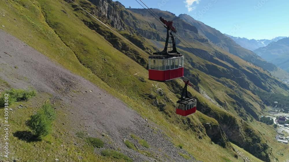 Aerial cinematic two red old gondola cabines disperse side by side ...