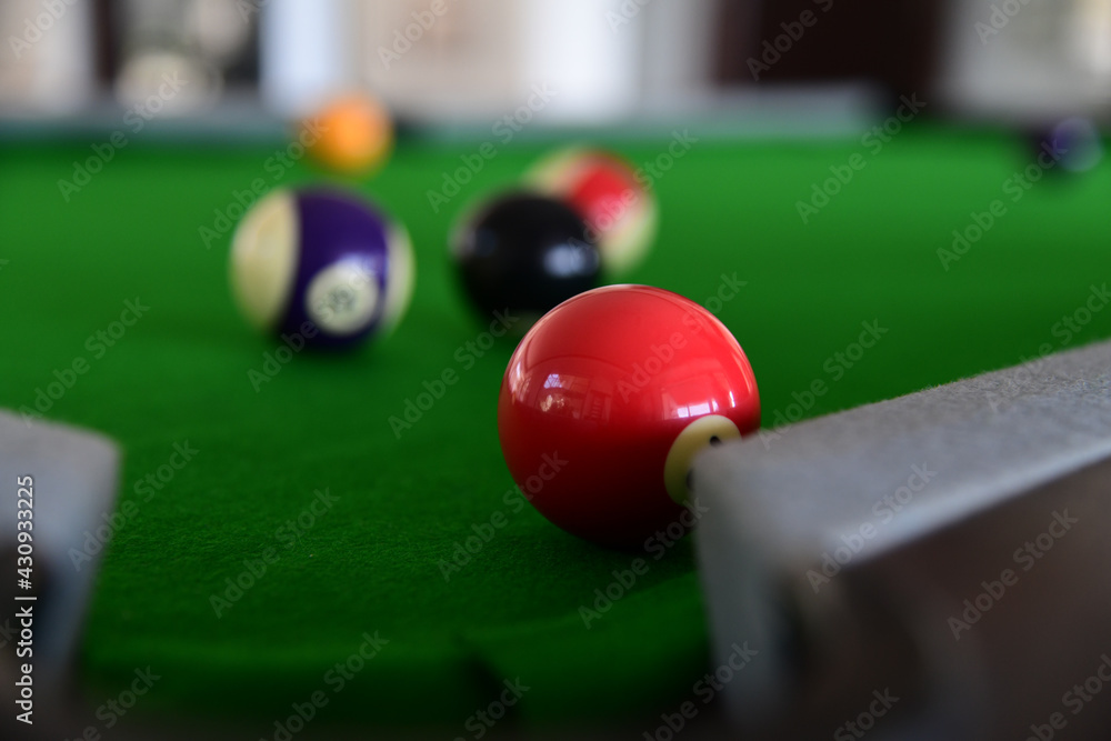 Green pool table composition with pool table balls. Focus on Red ball ...