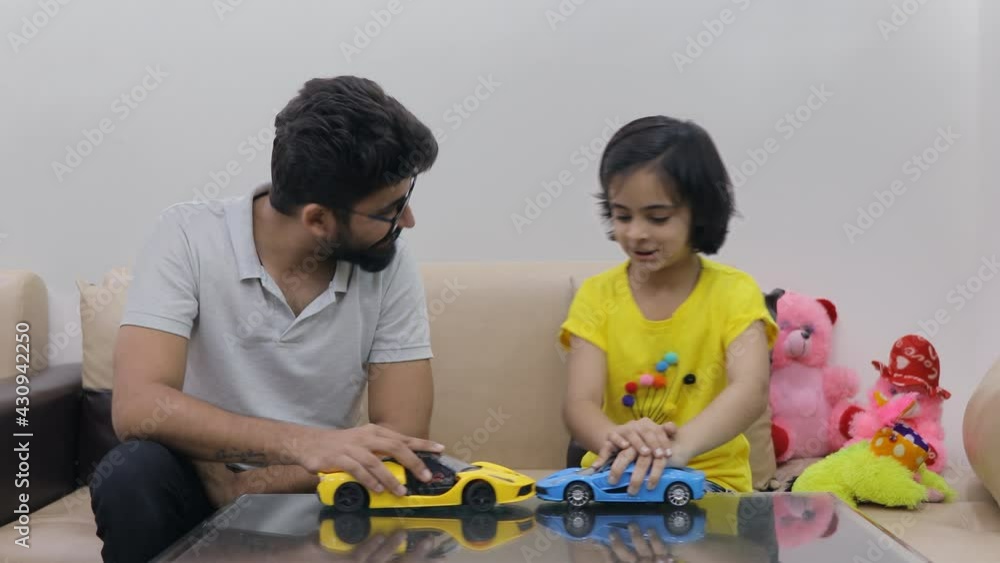 Father-daughter playfully doing a car fight on a table - happy family ...