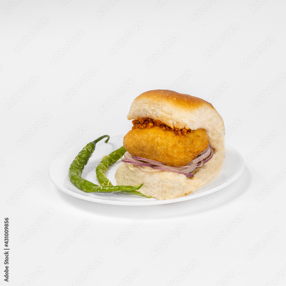 vadapaav or vada pav in a white plate with mirchi and chutney Stock ...
