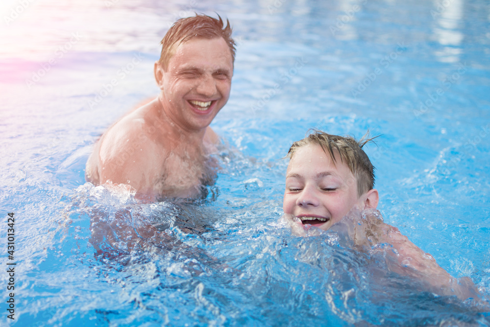 Happy family playing in water polo in the pool. Cute teenage boy and ...