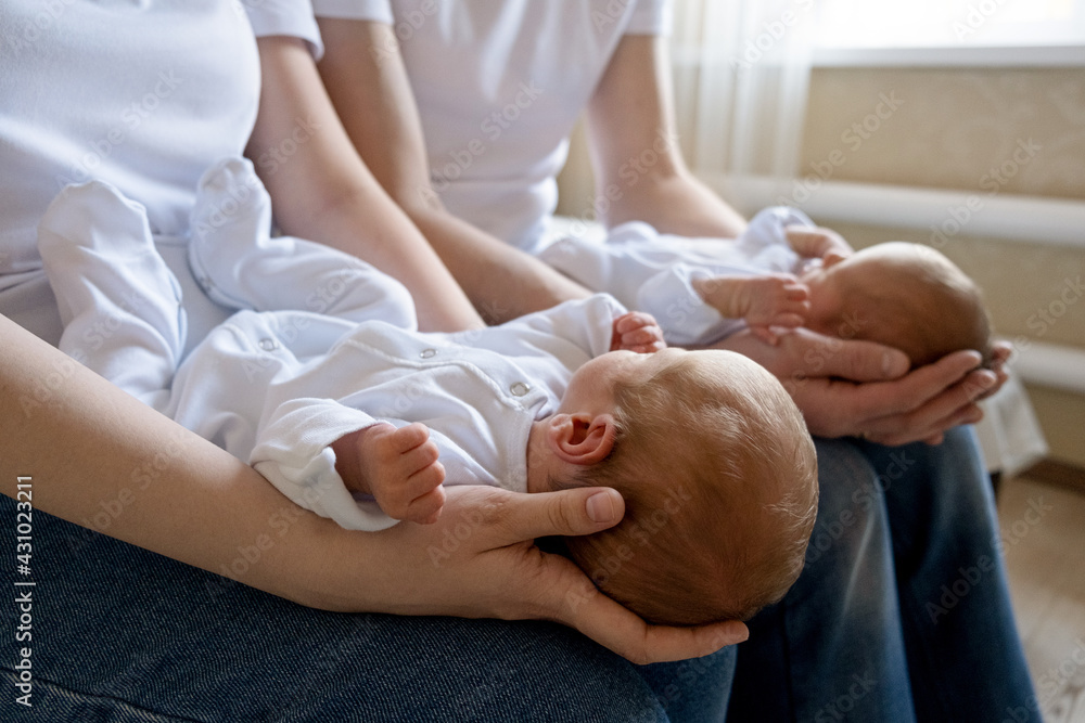 Newborn Identical twins on the bed, on a parents hands. Life style ...