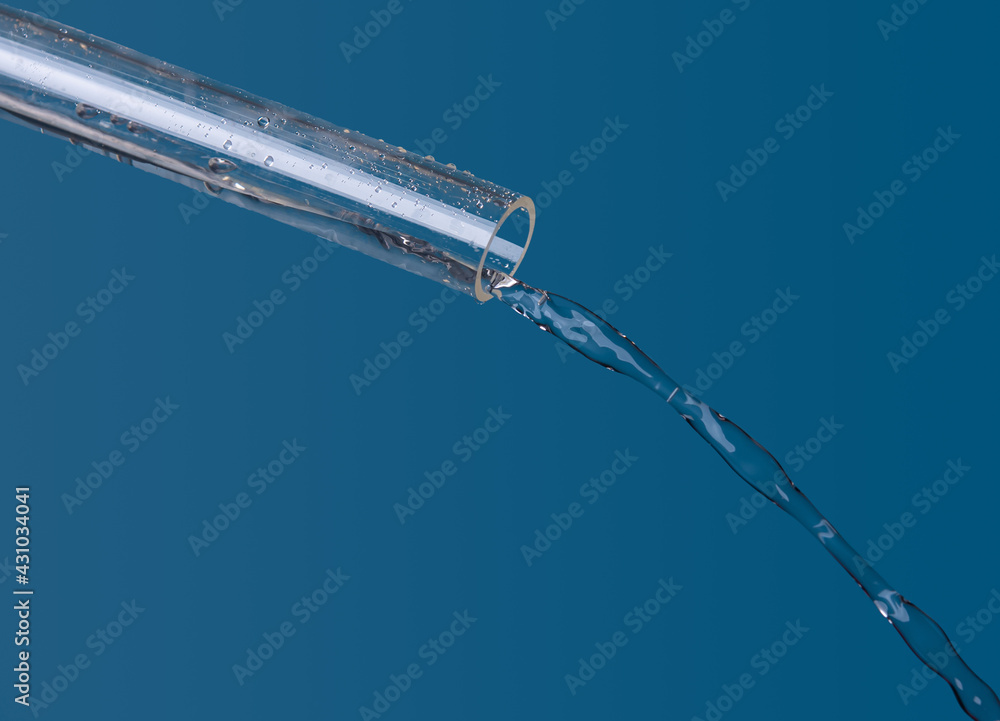 Water is pouring from a rubber hose, gardening tool on blue background ...