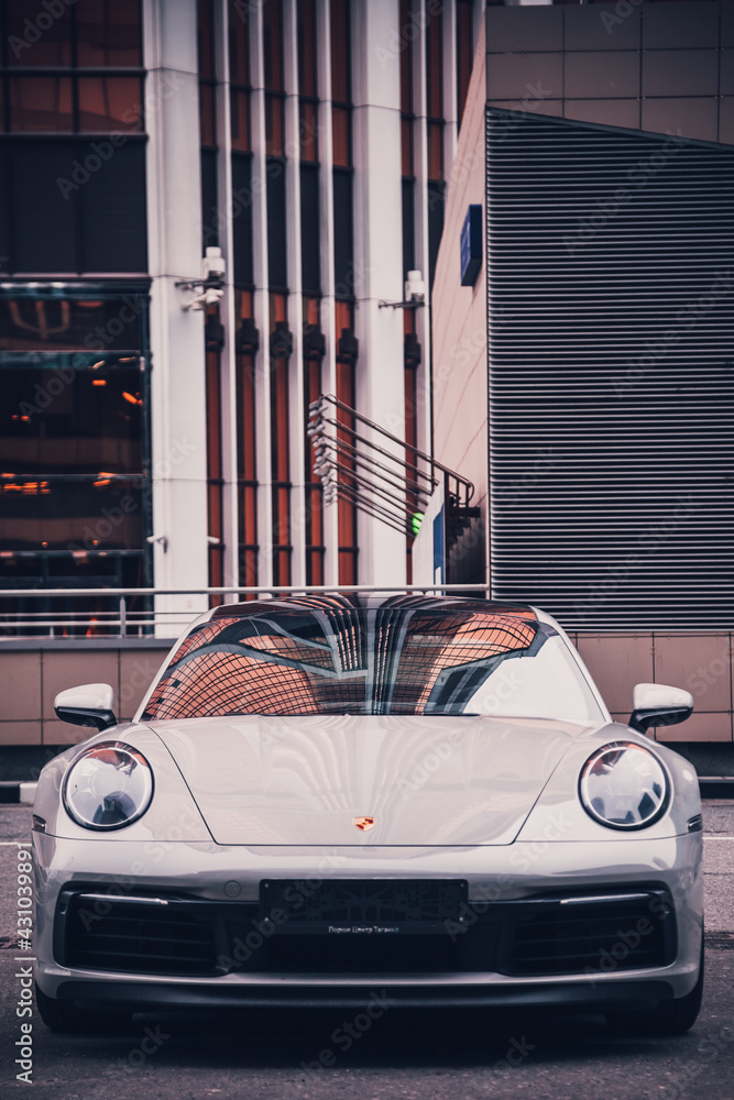 Foto de Front view of Porsche 911 in modern city area. Gray luxury ...