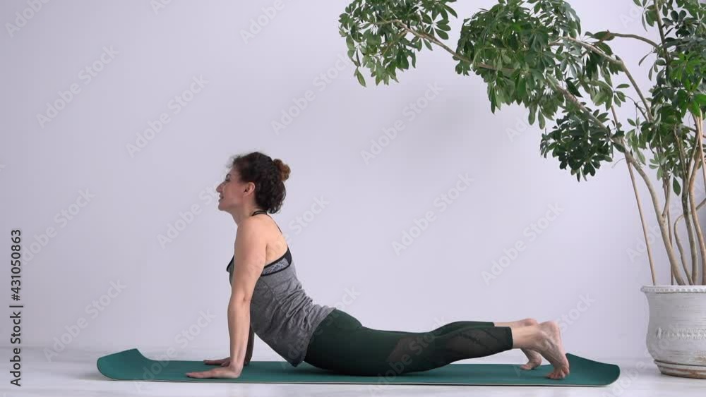 Cobra position. Attractive adult girl performs exercises while standing ...