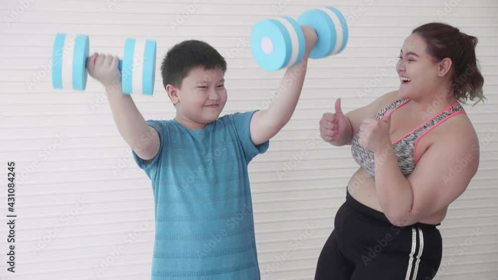 Asian family son fat exercise with dumbbell and mother cheer at home ...