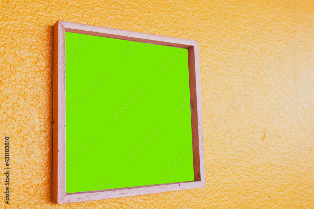 The picture frame on the wall has a green screen to insert content or ...