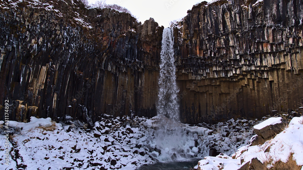 Beautiful view of famous cascade Svartifoss surrounded by volcanic ...