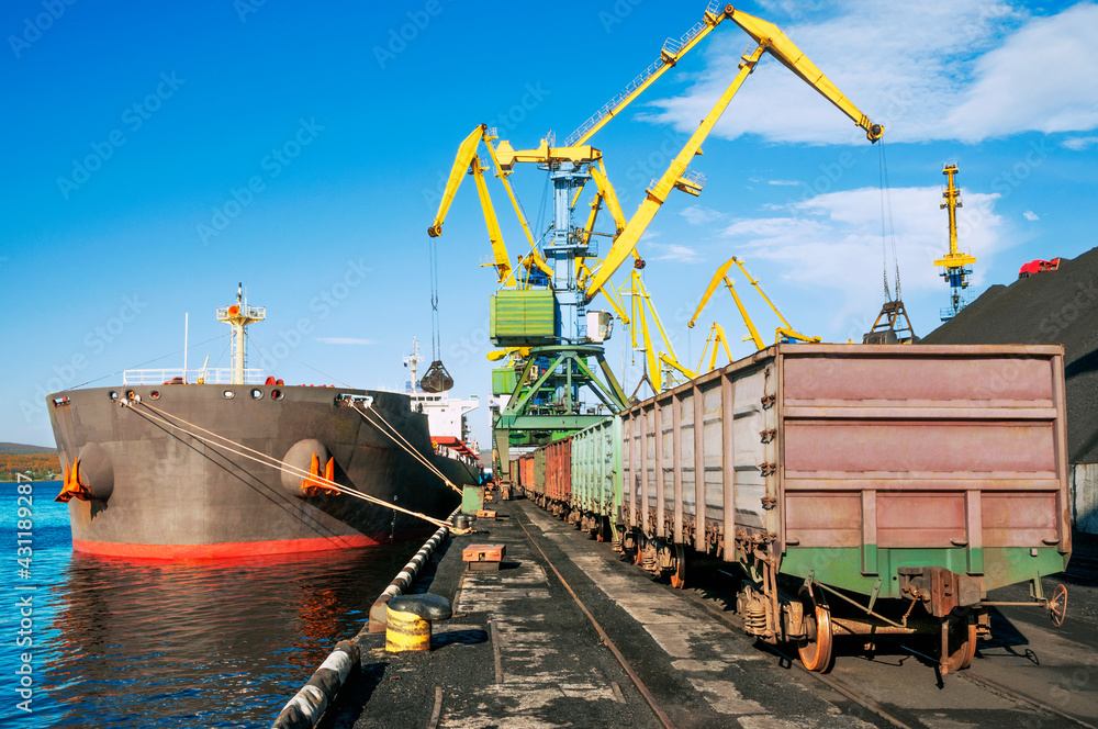 Loading coal into the holds of a dry cargo ship in the seaport. Stock ...