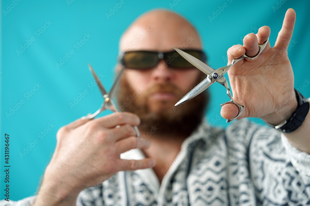 Tailor. A man with a beard holds a scissor in his hands. Guy with ...