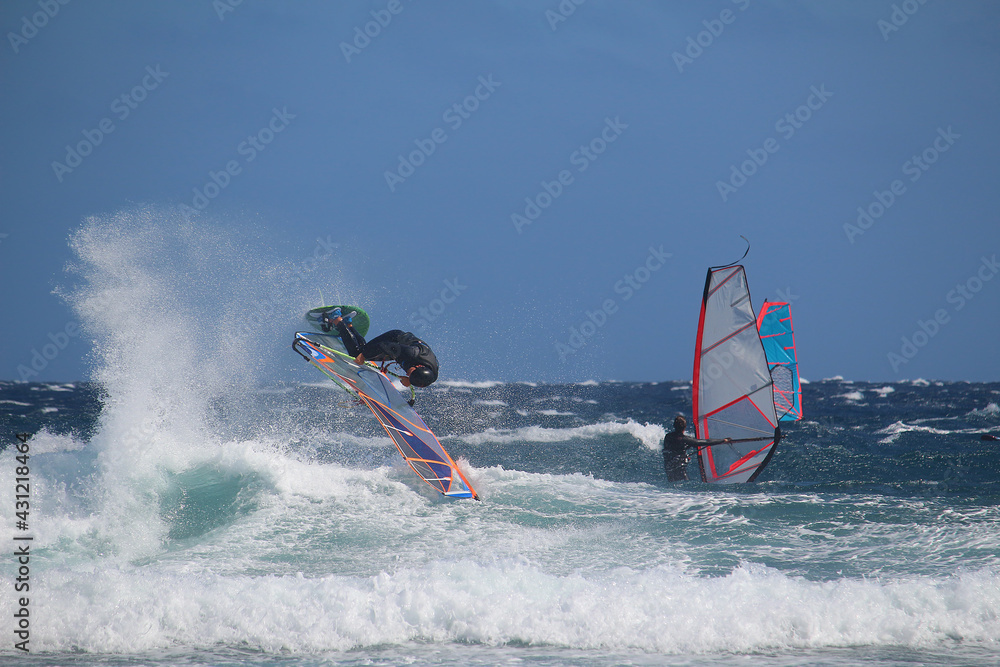 Windsurfer exercising a windsurf move in the wave at the Atlantic ocean ...