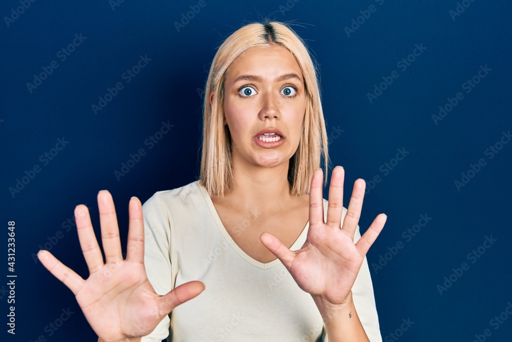 Foto de Beautiful blonde woman wearing casual sweater afraid and ...