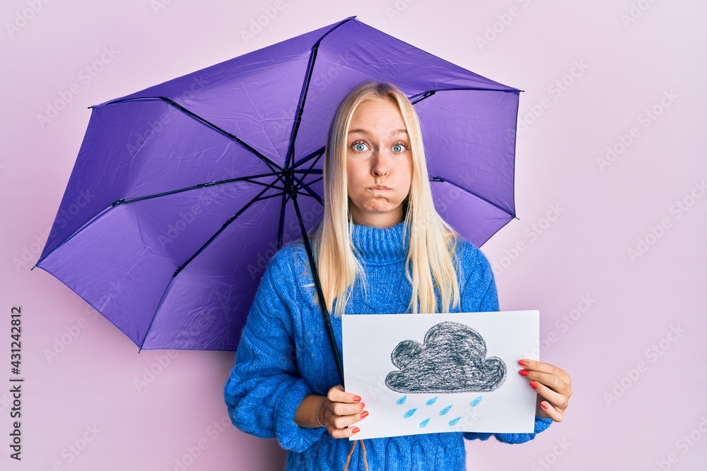 Young blonde girl holding umbrella rain draw puffing cheeks with funny ...