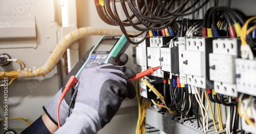 Electrician engineer tests electrical installations and wires on relay ...