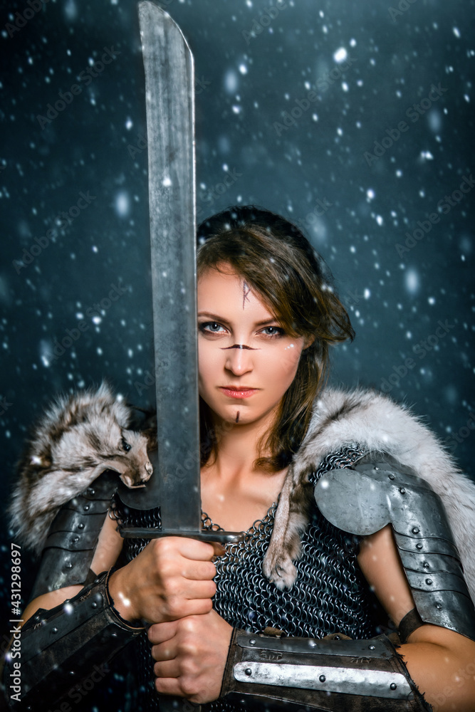 Portrait of a medieval woman warrior in chain mail and fur with a sword ...
