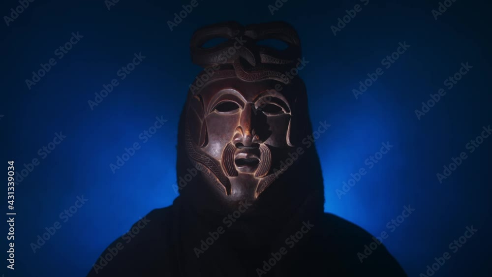 Creepy, masked cultist standing in a dark room. Scary horror scene ...