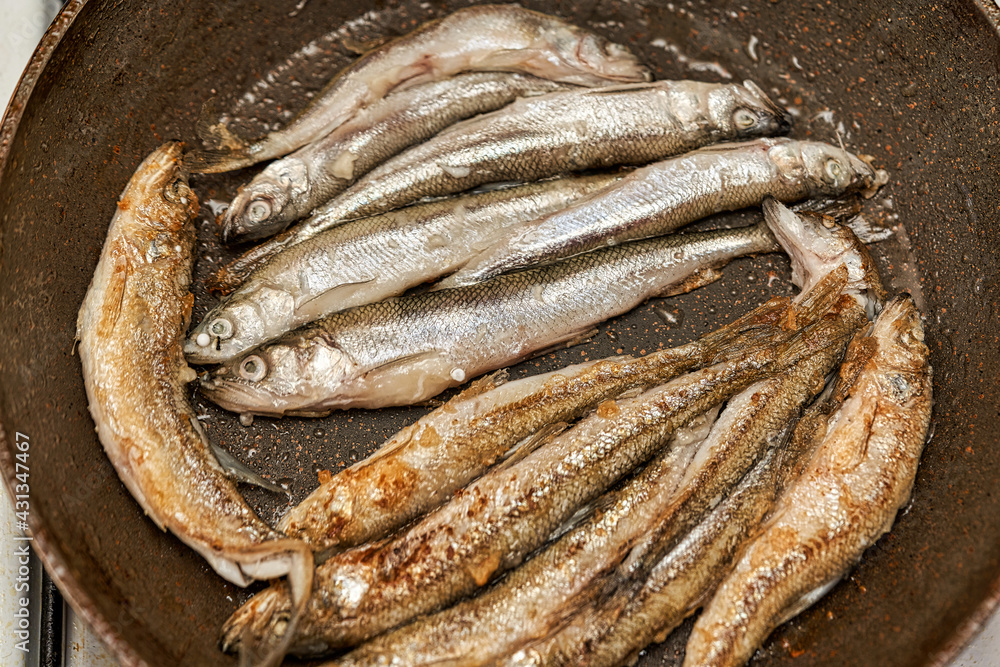 Crispy breaded European smelt in a black skillet. Stock Photo | Adobe Stock