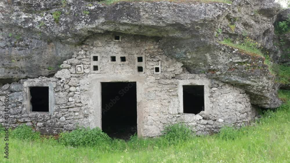 Stone cave house - vintage front wall of a hut built as shelter or home ...