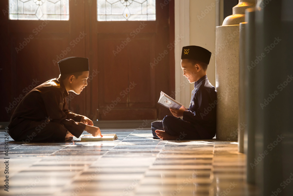 An Islamic child prays to study with his sister and brother in a mosque ...