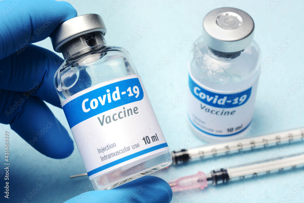 Doctor as vaccinator in vaccination center shows vial with vaccine ...