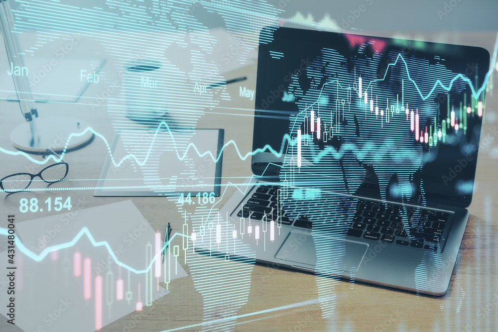 World map and trading charts with a laptop on the desk in the ...