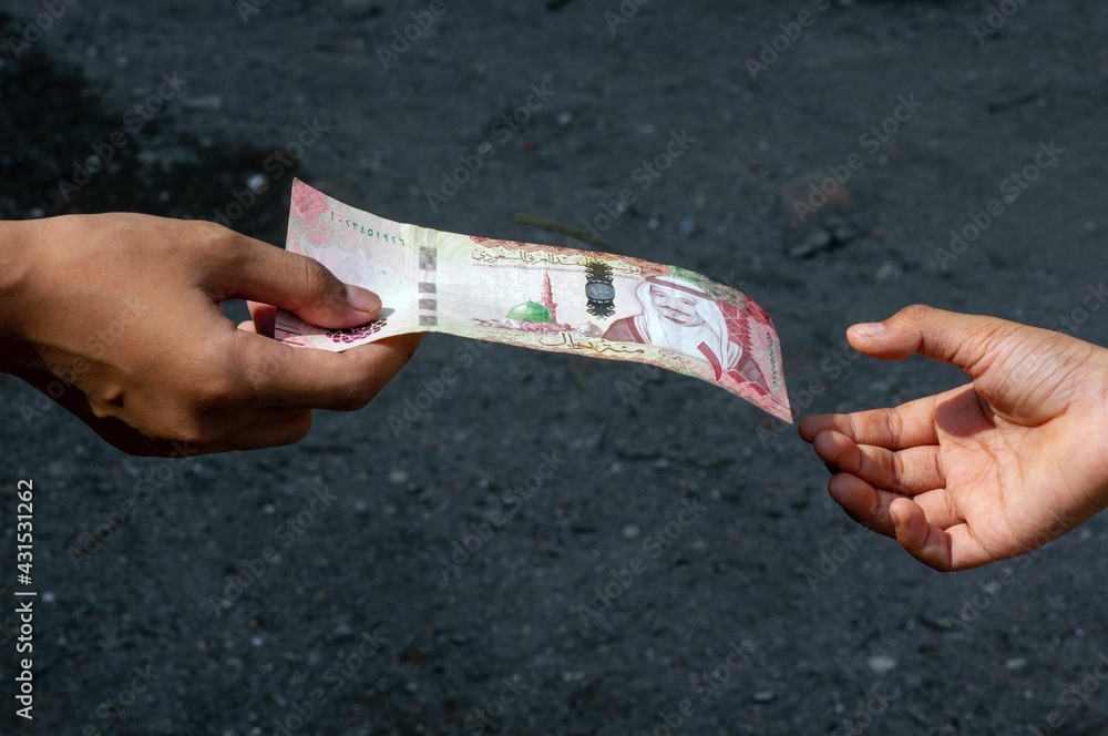 Asian children hand with 100 Riyal, the currency of Saudi Arabia ...