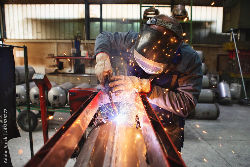 Worker is welding metal tubes, man hand welding inox boiler with argon ...