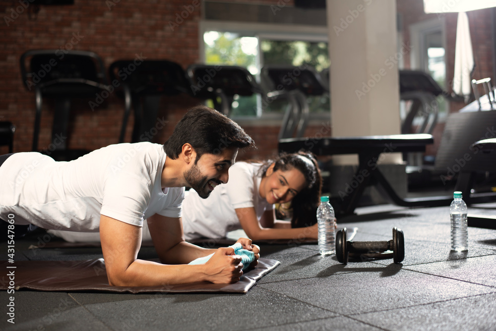 Indian asian young couple doing Plank exercise in gym Stock Photo ...