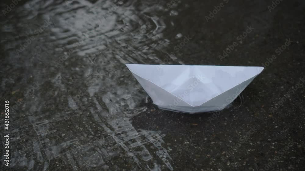 Paper boat on the surface of rainwater. Run aground. A symbol of ...