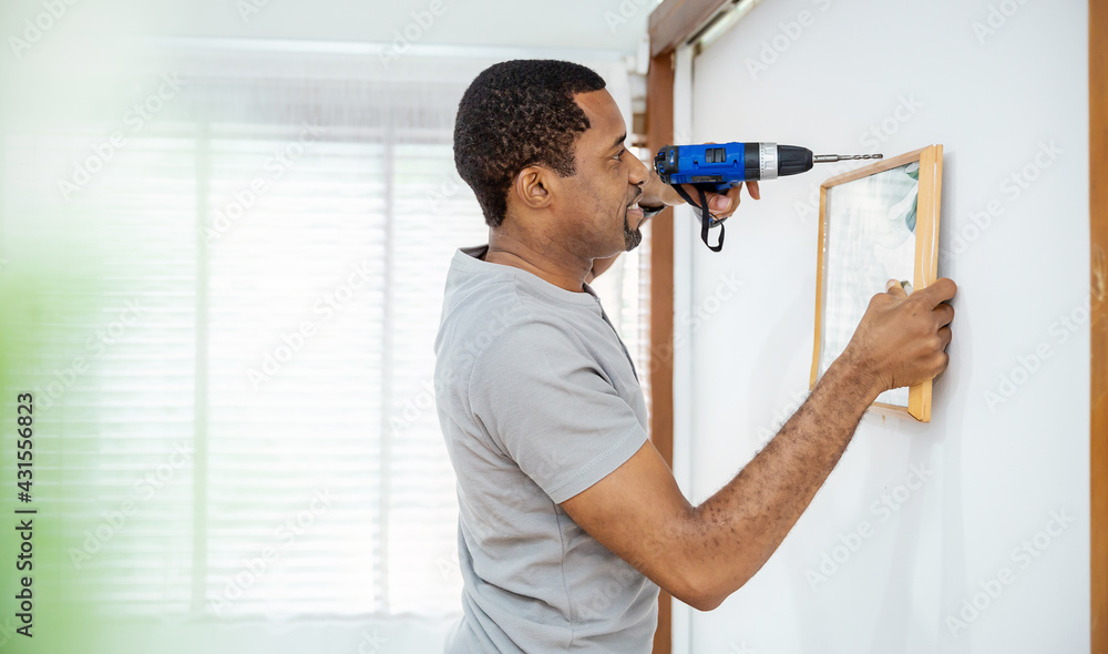 Portrait of happy handsome African American black man using electric ...