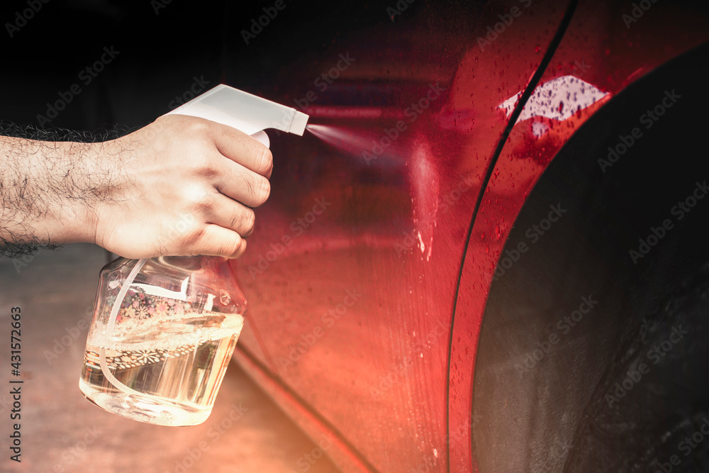 The human hand was spraying chemical liquid onto the car body with a ...