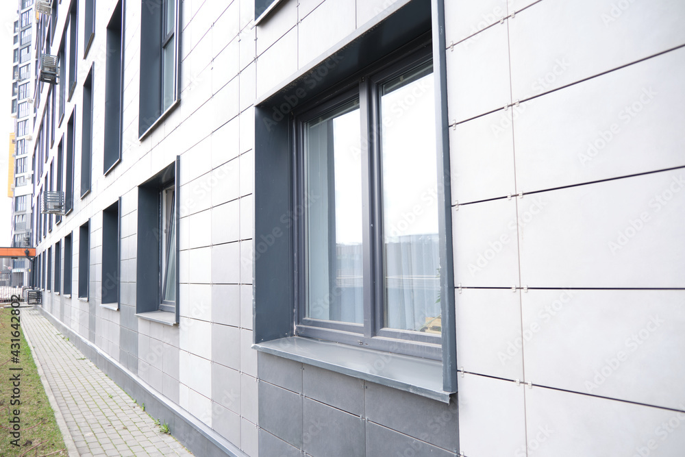 wall of office building made of metal plates with windows. Detail of ...