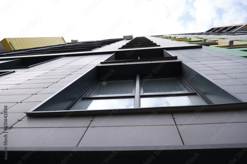wall of office building made of metal plates with windows. Detail of ...